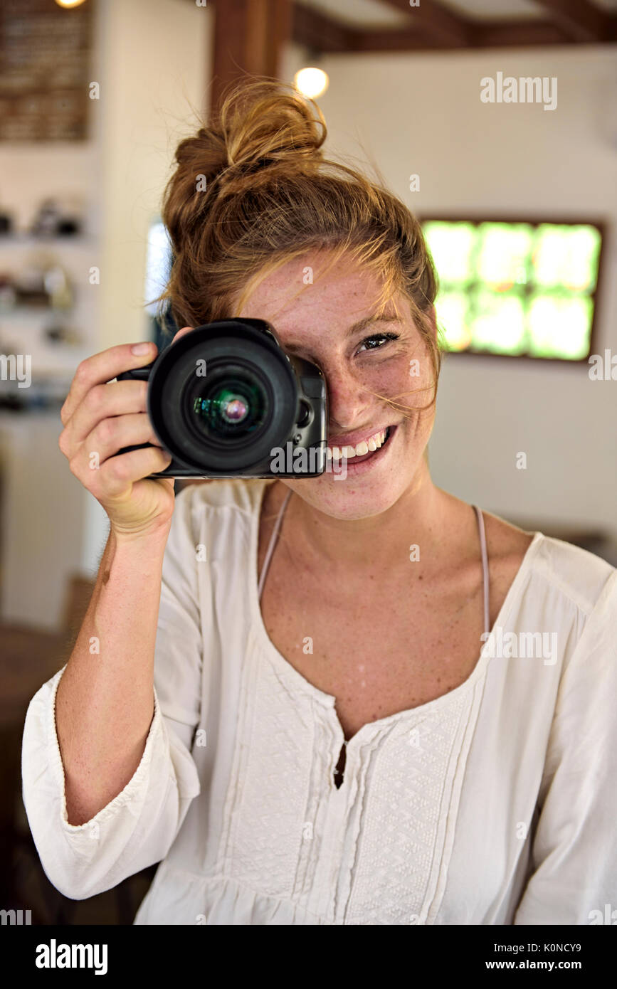 Portrait of laughing young woman taking picture with camera Stock Photo ...