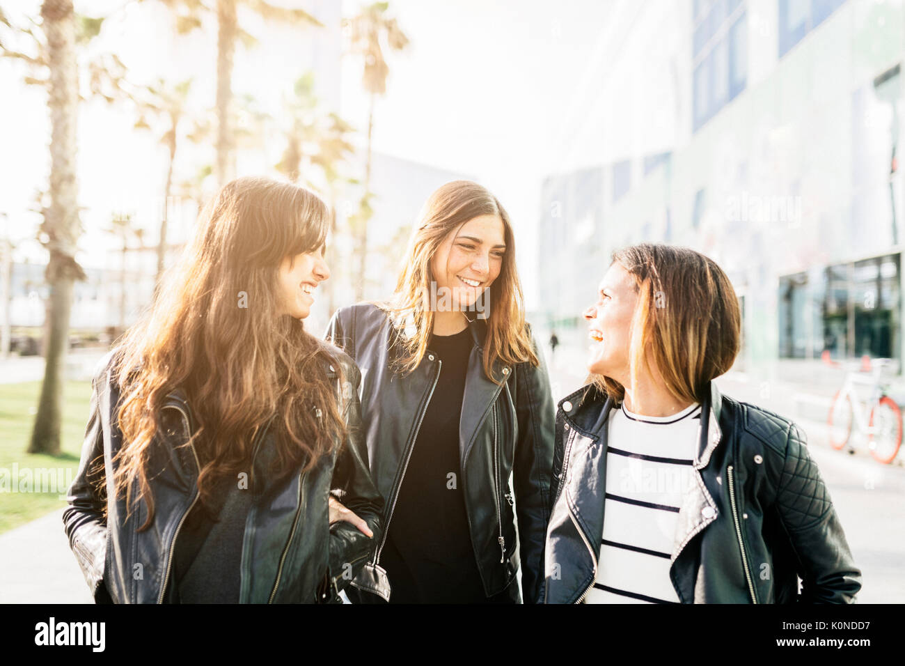 Three friends wearing black leather jackets having fun Stock Photo - Alamy