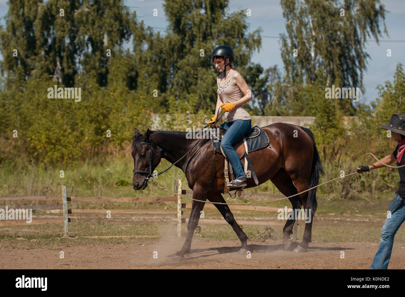 Horseback riding lessons - young woman riding a horse Stock Photo - Alamy