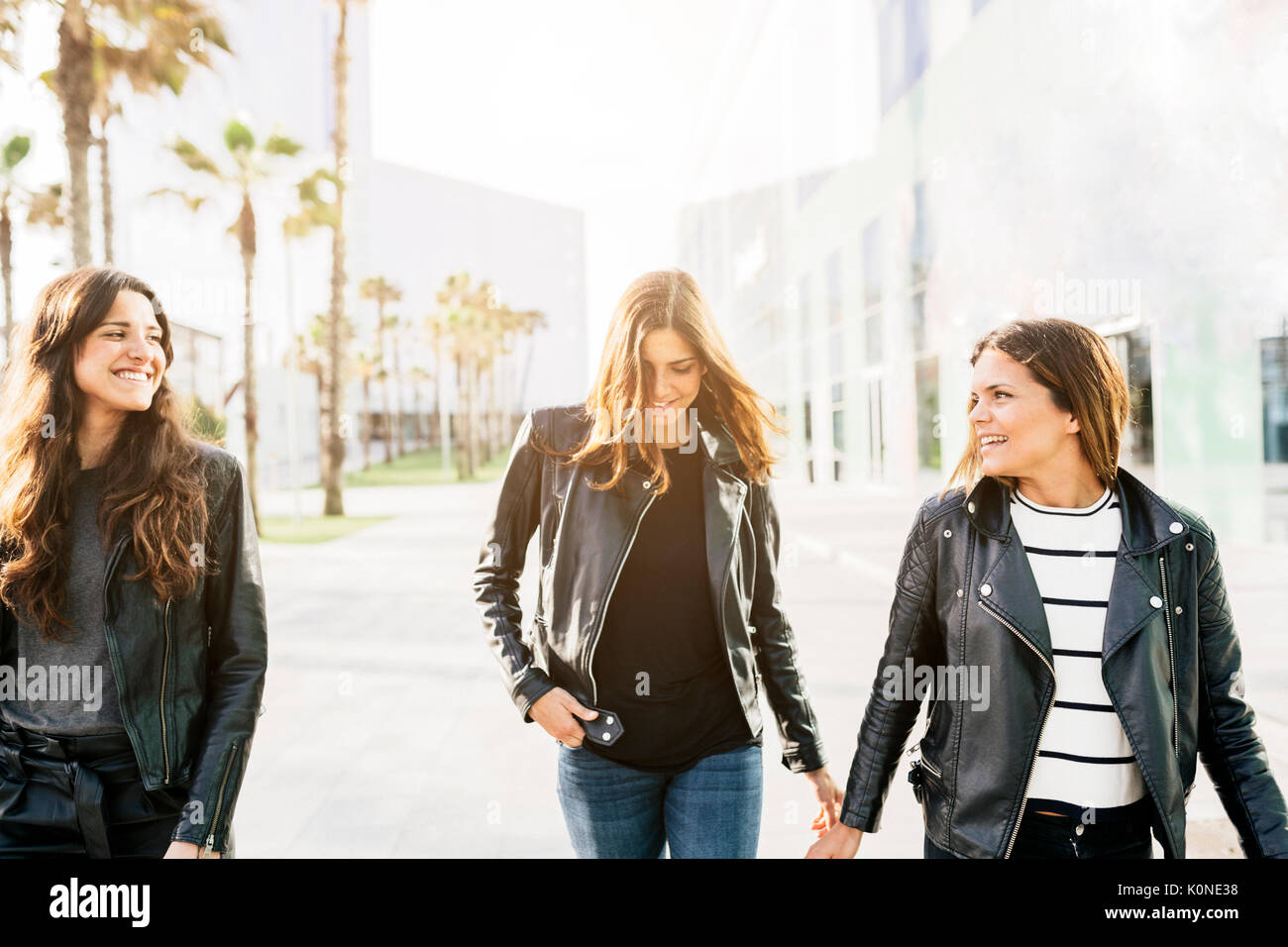 Three happy friends wearing black leather jackets Stock Photo - Alamy