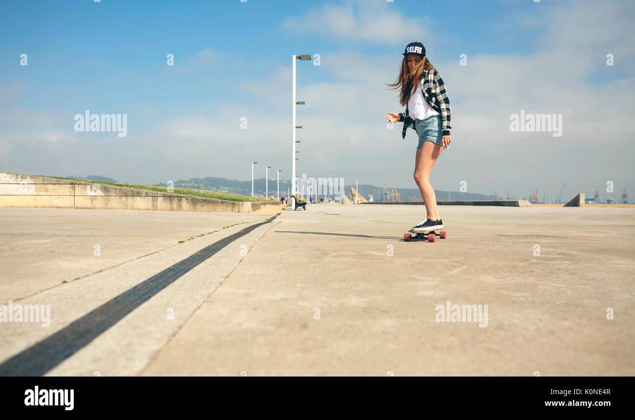 Young woman longboarding on beach promenade Stock Photo - Alamy