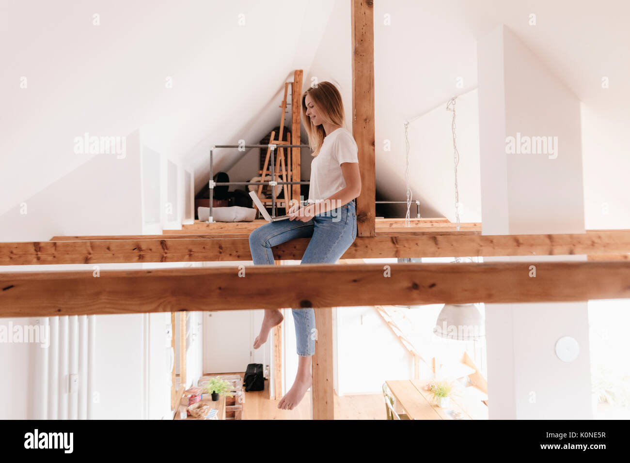 Young woman sitting on wooden beam hi-res stock photography and images ...