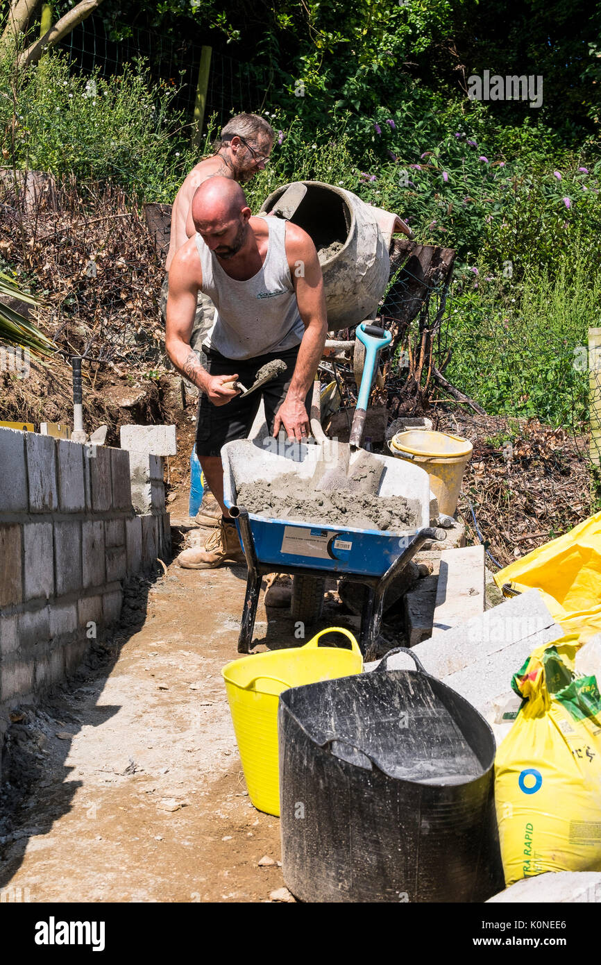 Workers building a block wall on a building site Stock Photo - Alamy