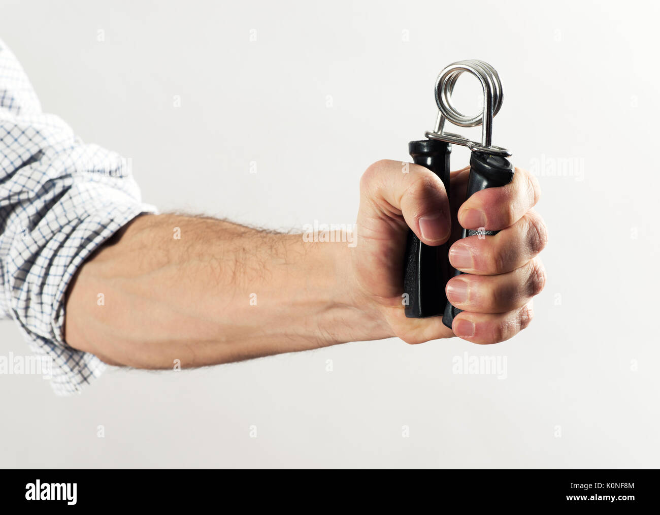 Man forcing together a strong spring with his fist in a concept of ...