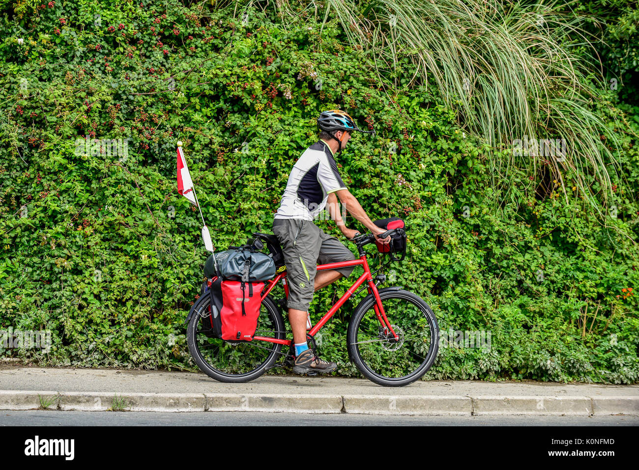 A touring cyclist riding on a pavement in Newquay in Cornwall Stock ...