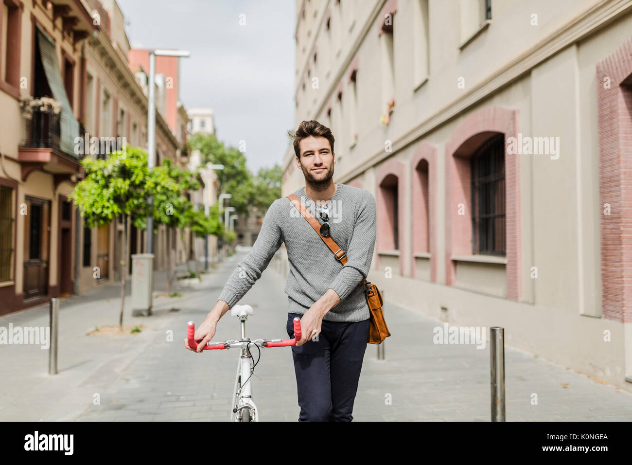Young man pushing his bike Stock Photo - Alamy