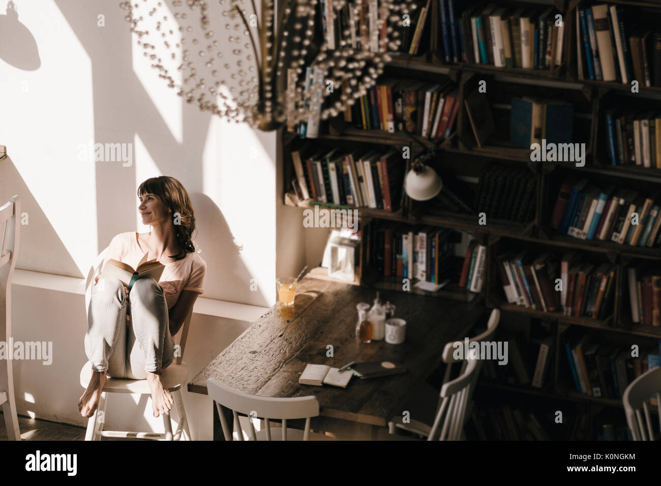 Woman reading book in cafe Stock Photo - Alamy