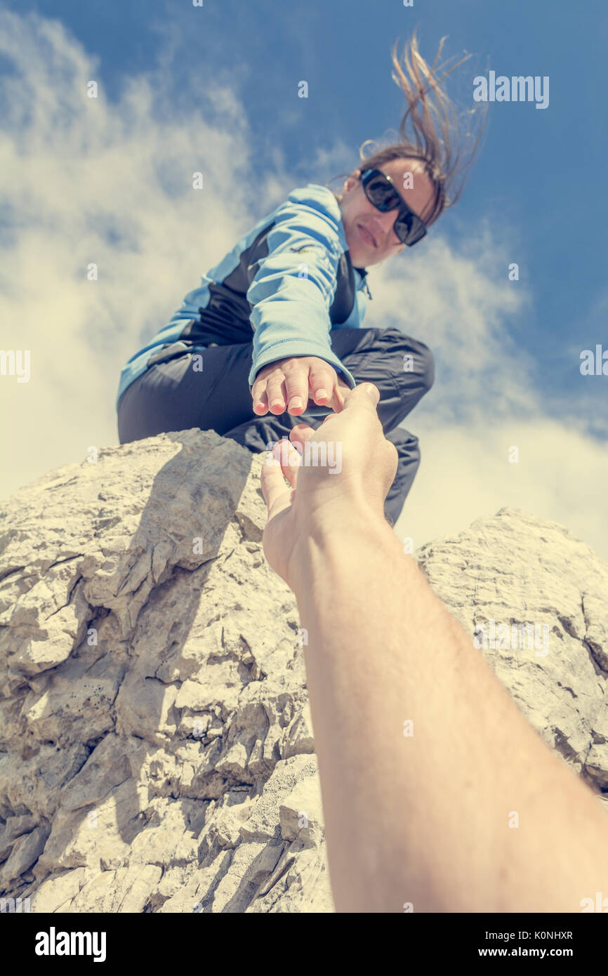 Female climber giving a helping hand. Teamwork and help concept Stock ...