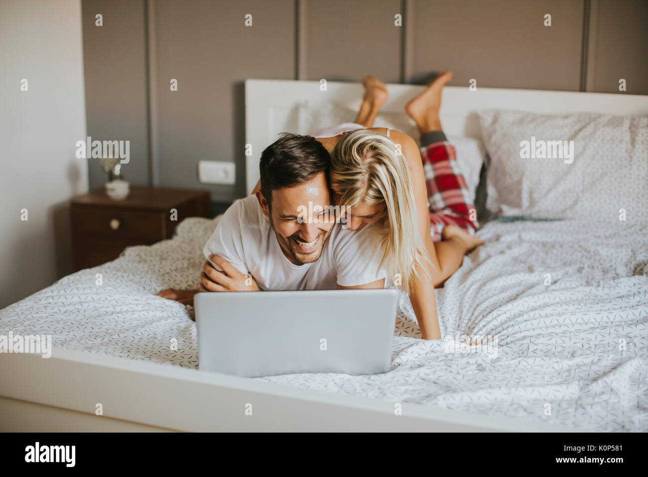 Intimate lovers using laptop lying on the bed in the bedroom Stock Photo - Alamy