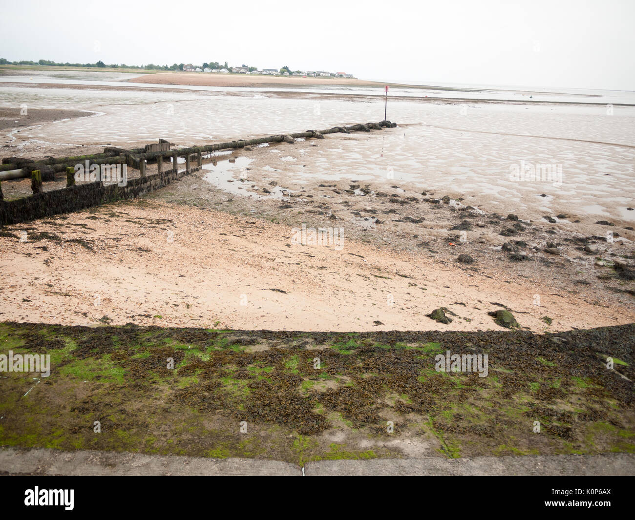 curved seaside scene pipe groyne beach seaweed pebbles; England; UK ...