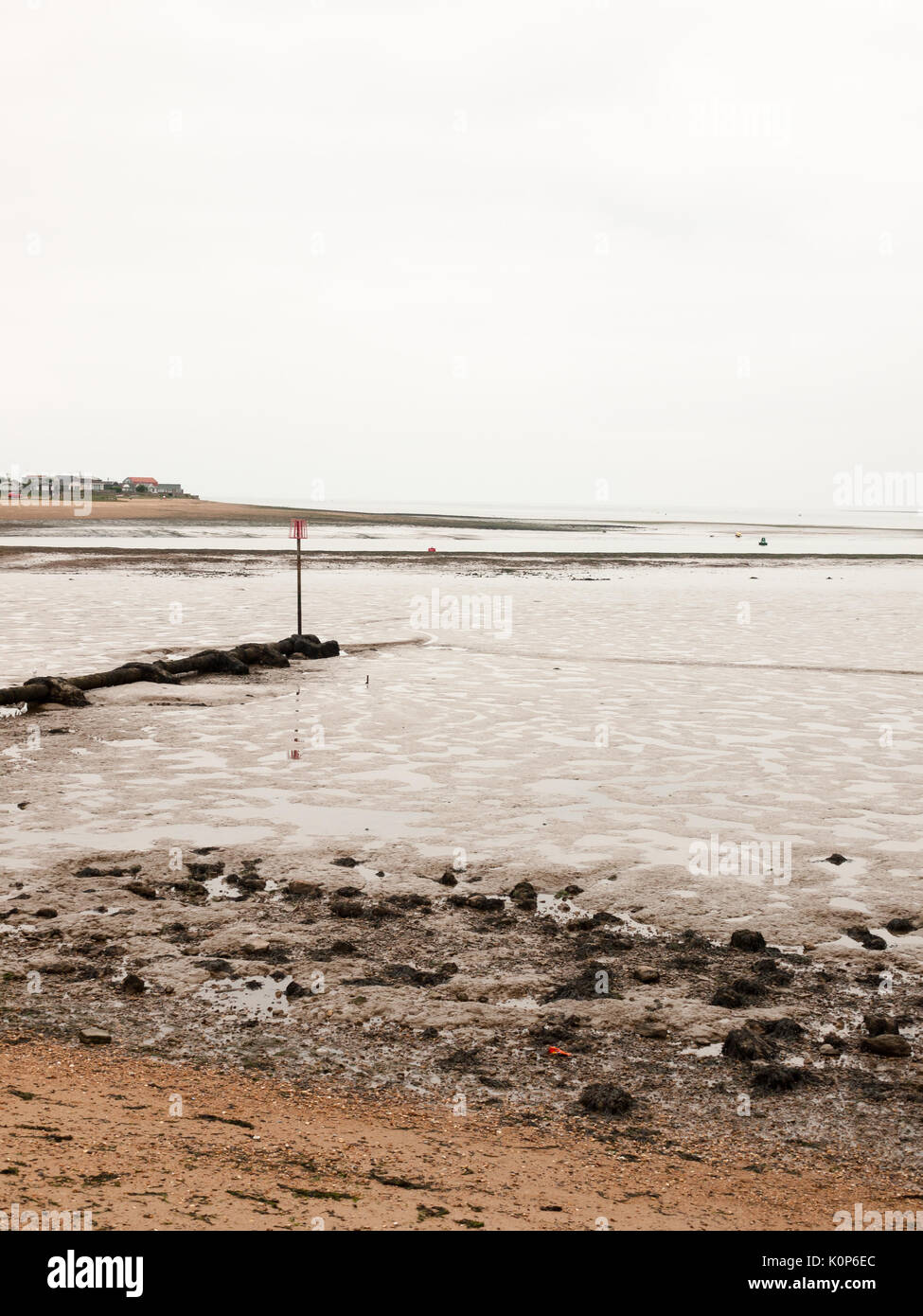 curved seaside scene pipe groyne beach seaweed pebbles; England; UK ...