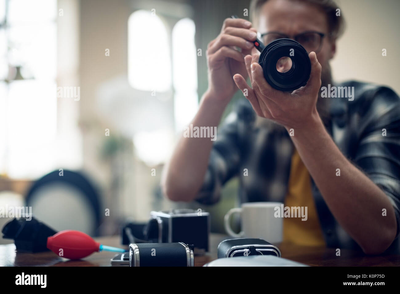 Photographer cleaning camera lens while sitting in studio Stock Photo ...