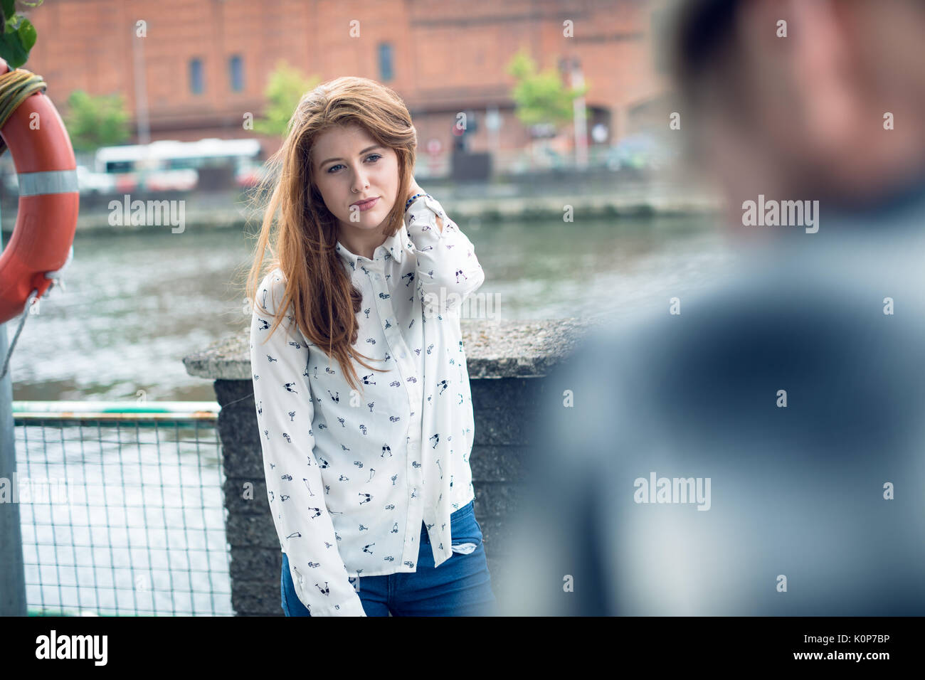 Photographer photographing fashion model standing against river in city ...