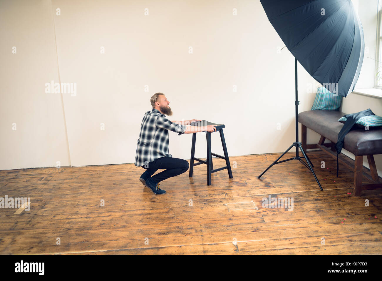 Side view of photographer crouching while working in studio Stock Photo ...
