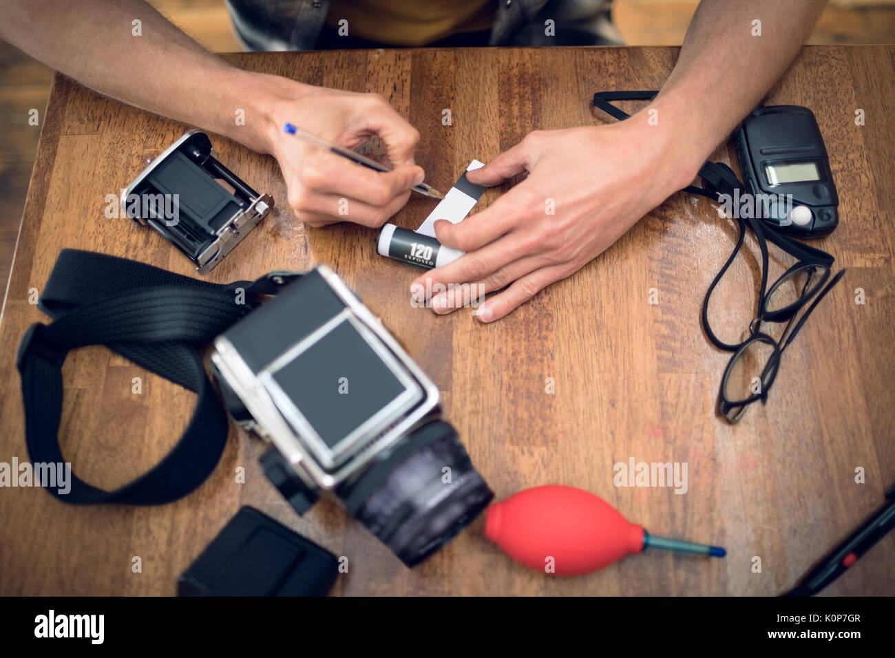 Photographer writing on film reel at table in studio Stock Photo - Alamy