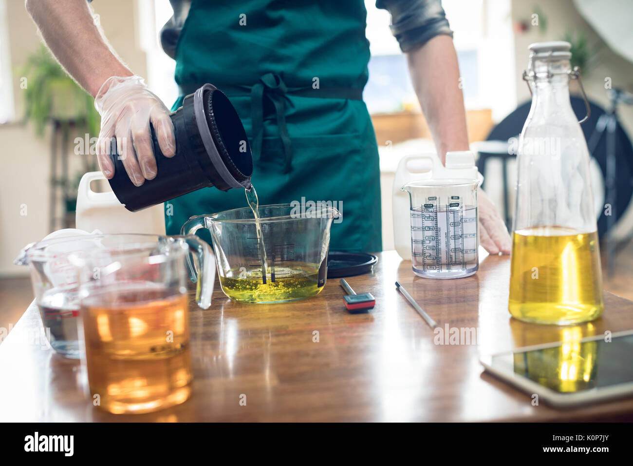 Mid section of photographer pouring chemical in container while working ...