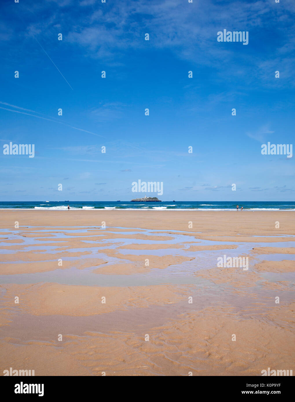 wide sandy beach El Puntal, Santander Bay, small island Isla de Mouro ...