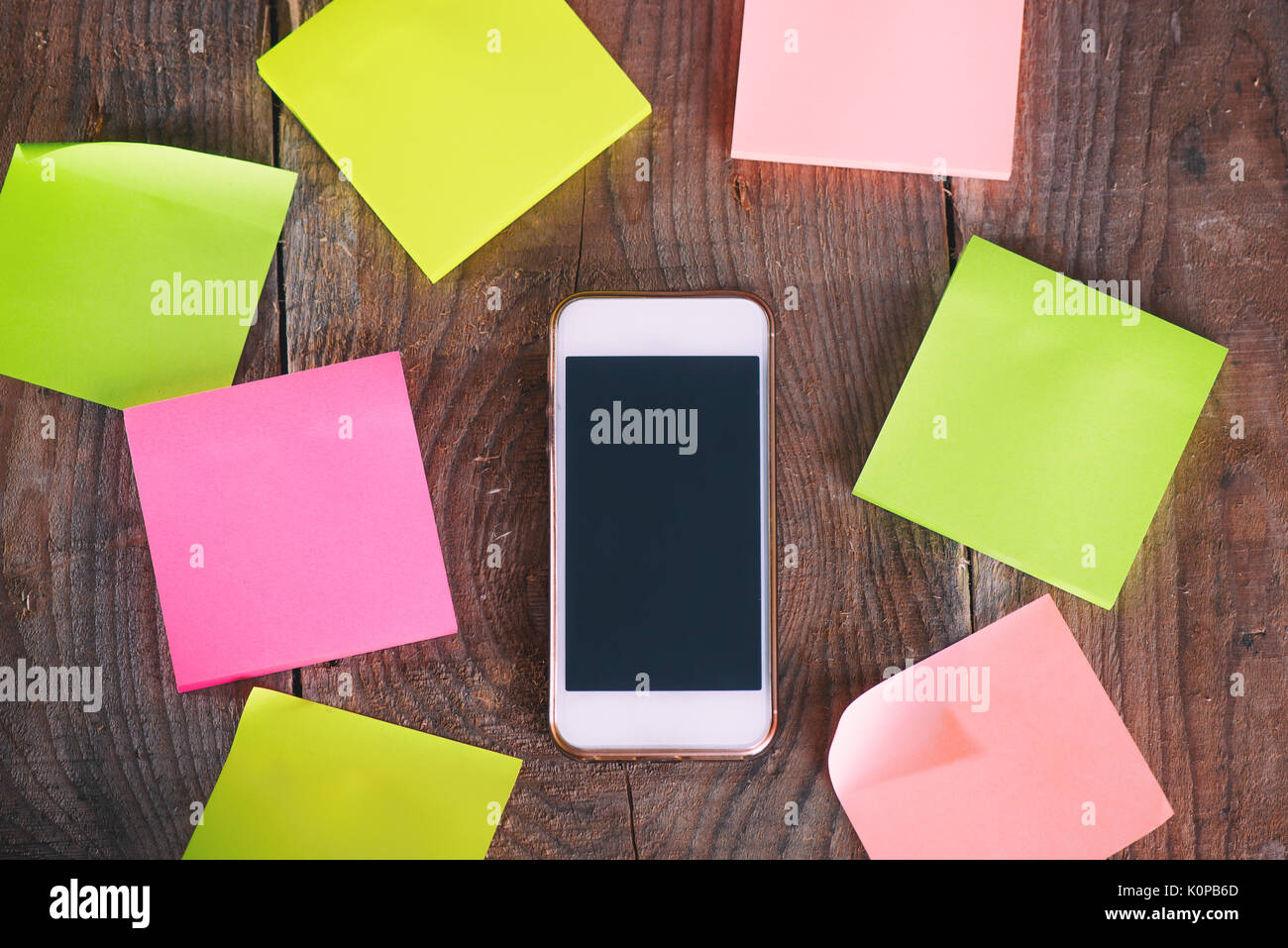 Smartphone with black screen and colorfull paper notes on wooden ...