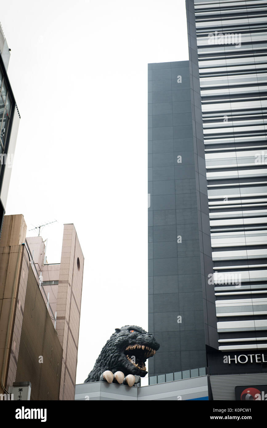 Godzilla head surrounded by tall building Stock Photo - Alamy
