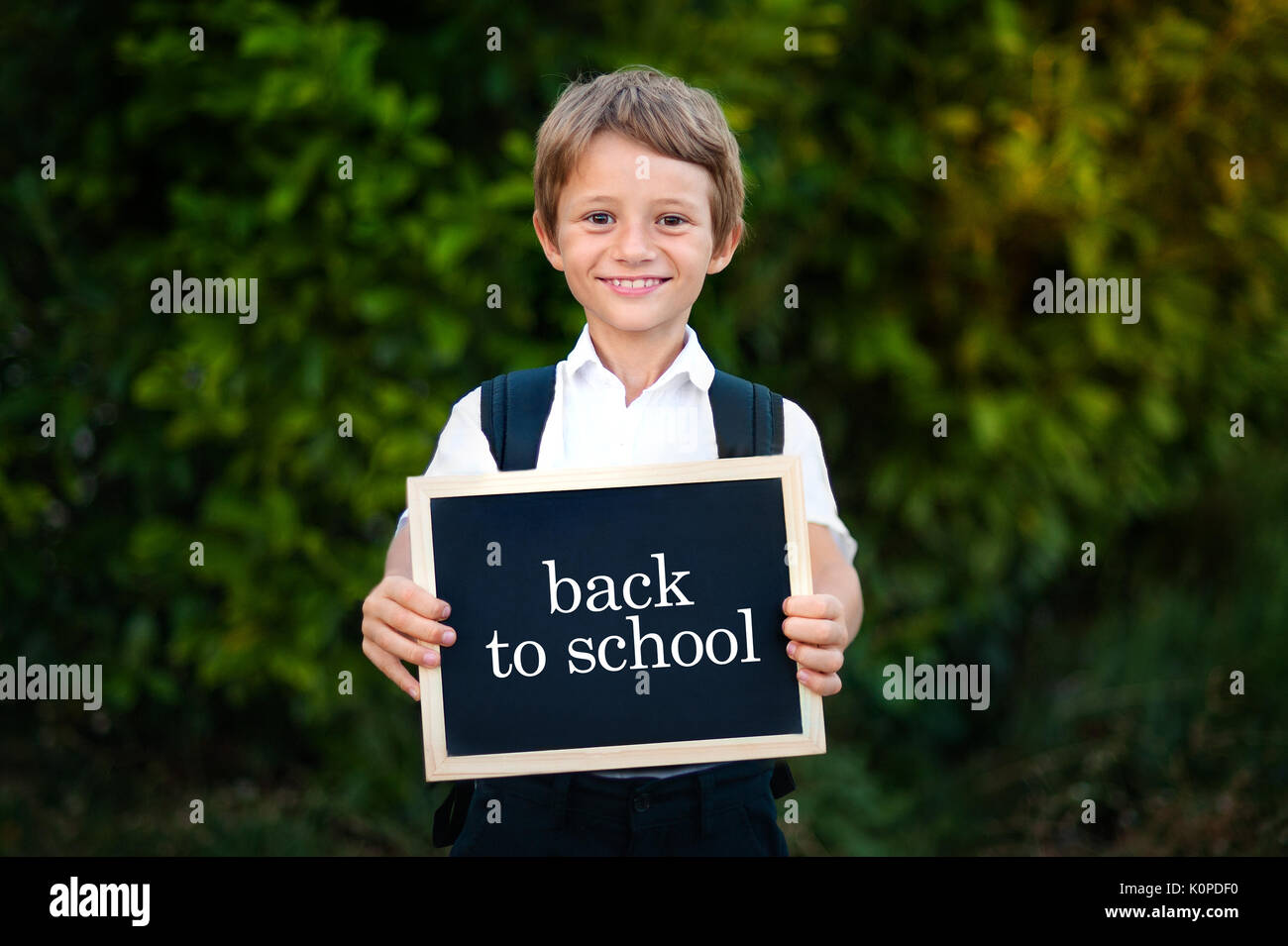 Back to school concept. Elementary school student boy holding ...