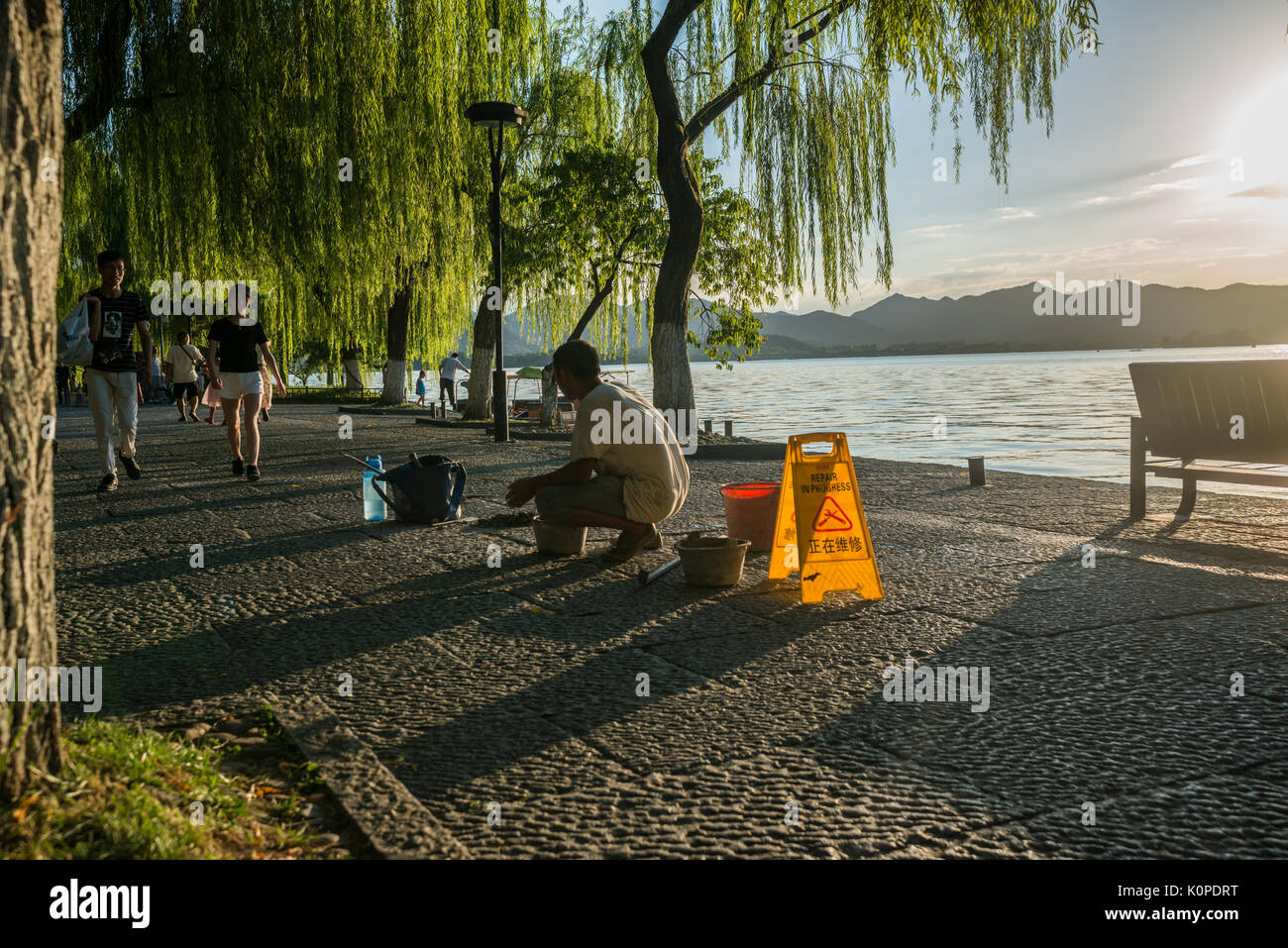 Chinese manual worker repairing the stone path, sidewalk in early ...
