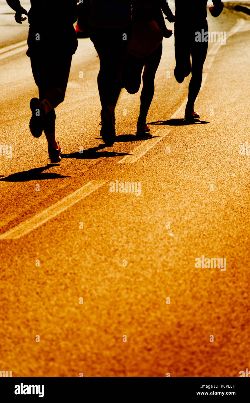 detail of the legs of four marathon runners in silhouette Stock Photo ...
