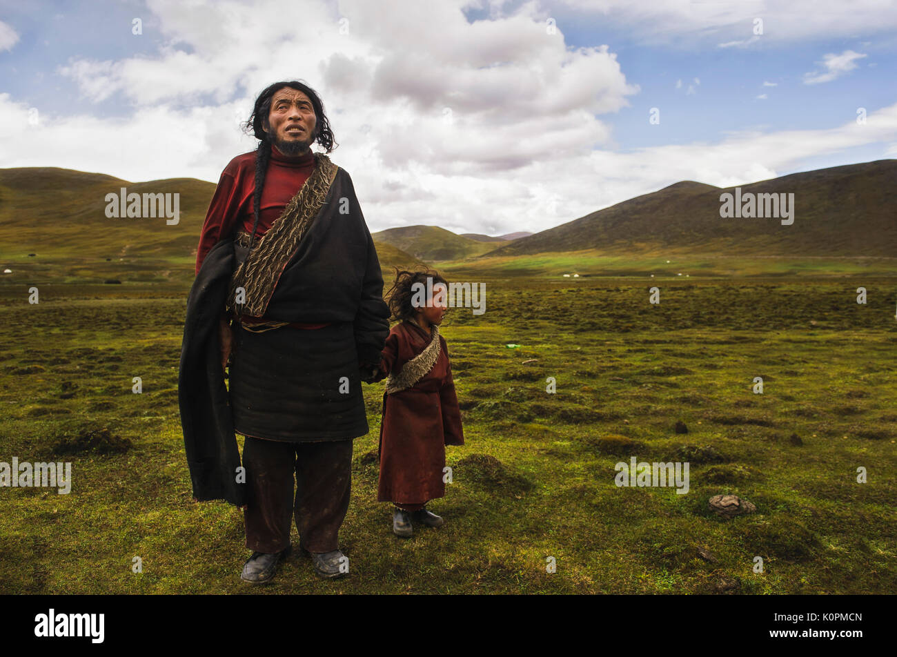 A Tibetan nomad father with his son somewhere in the grasslands of the ...