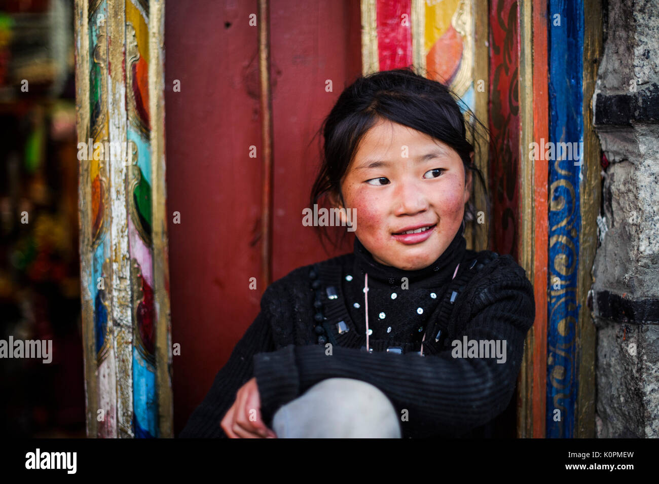Portrait of a Tibetan kid out in the cold with his cheeks reddened by ...
