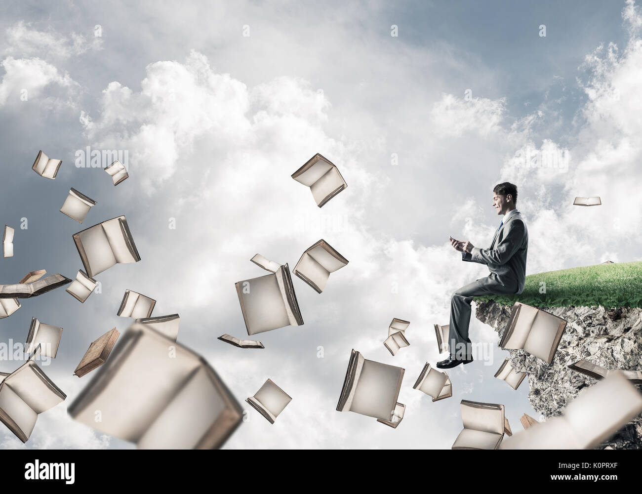 Man using smarphone and many books flying in air Stock Photo - Alamy