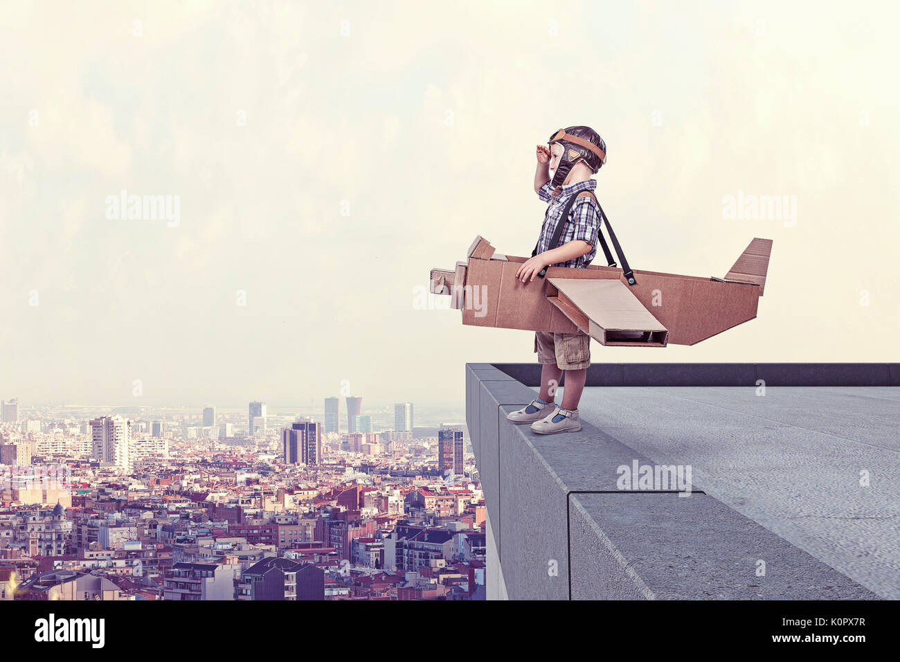 child aviator with cardboard airplane on top building Stock Photo - Alamy