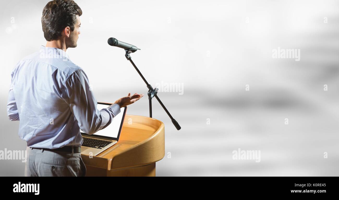 Digital composite of Businessman on podium speaking at conference with ...