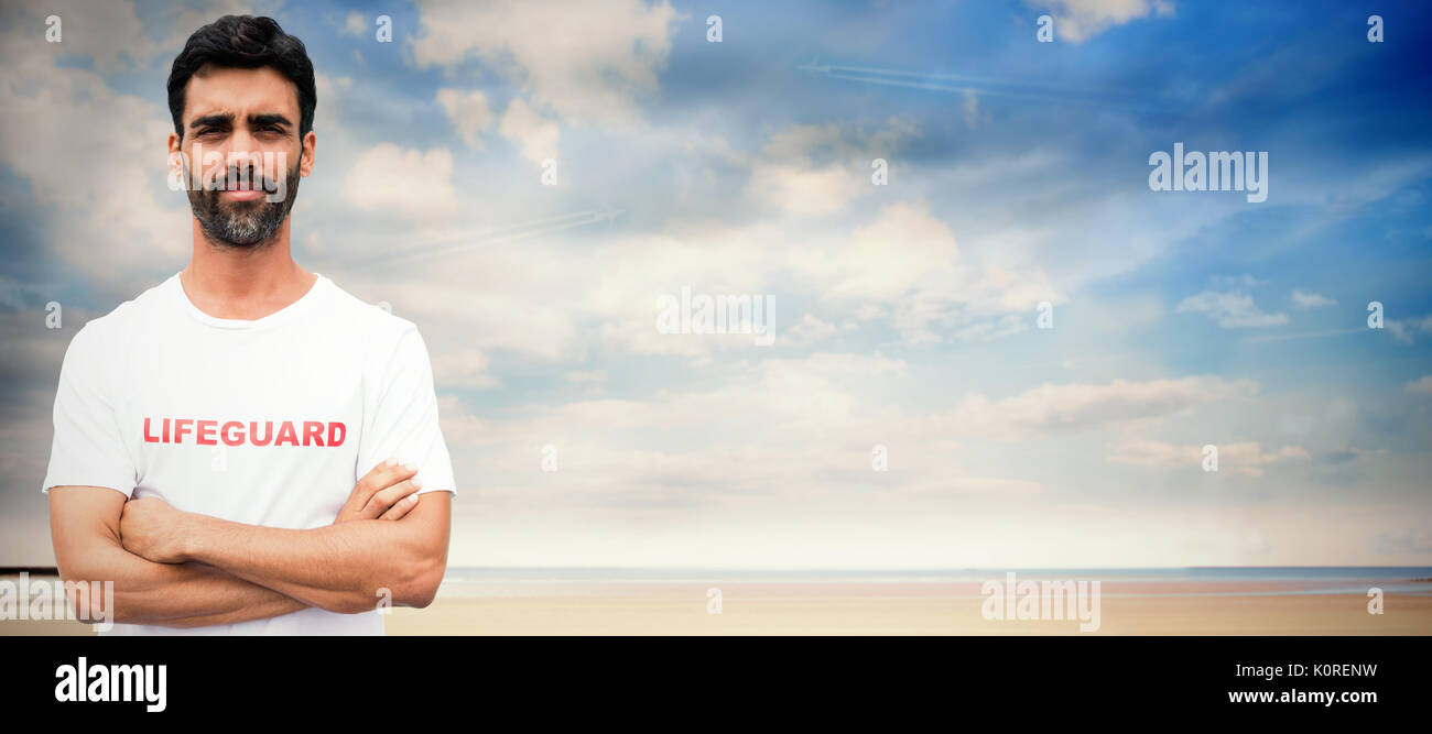 Portrait of male lifeguard with arms crossed against serene beach ...