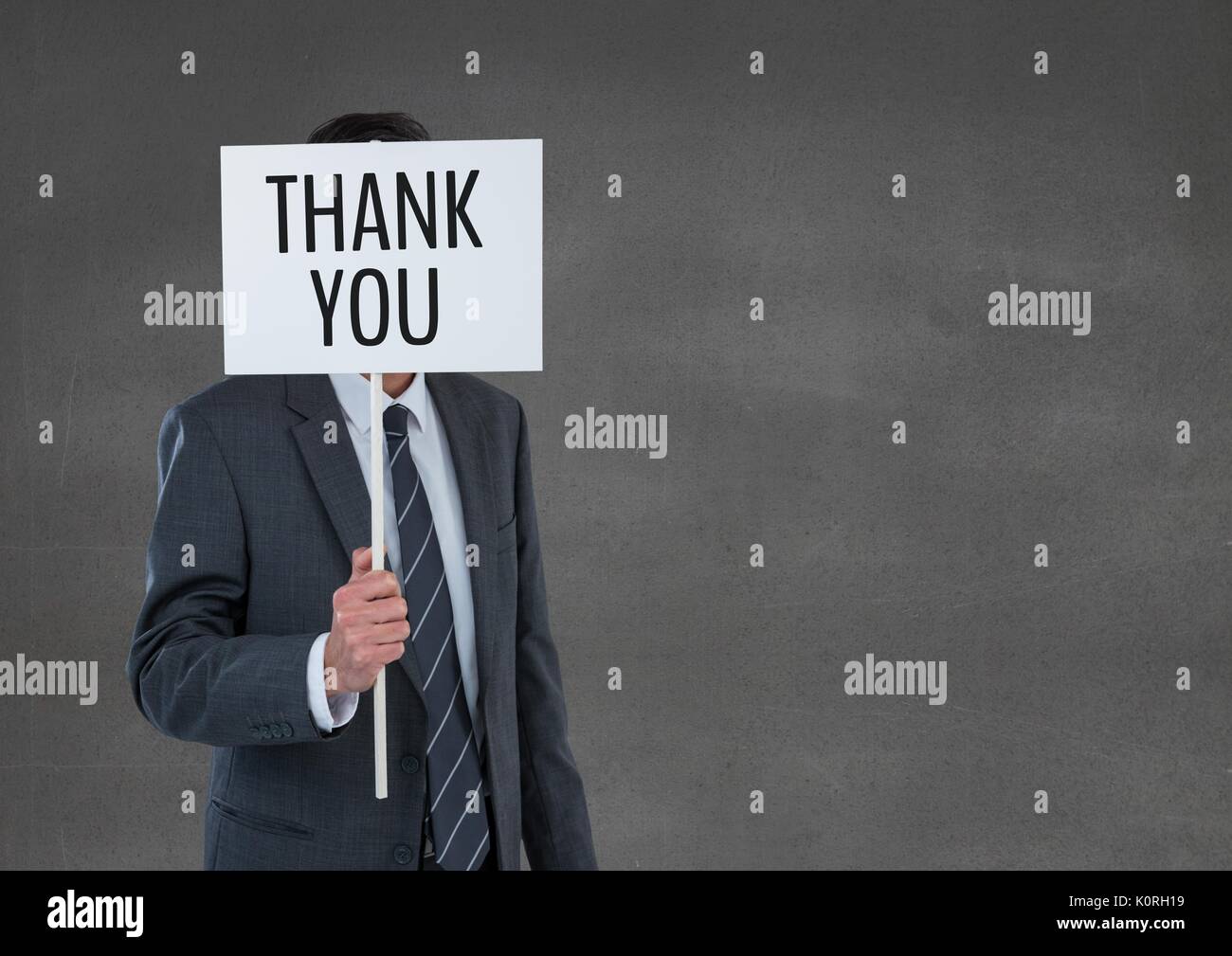 Digital composite of Business man holding a card with thank you text ...