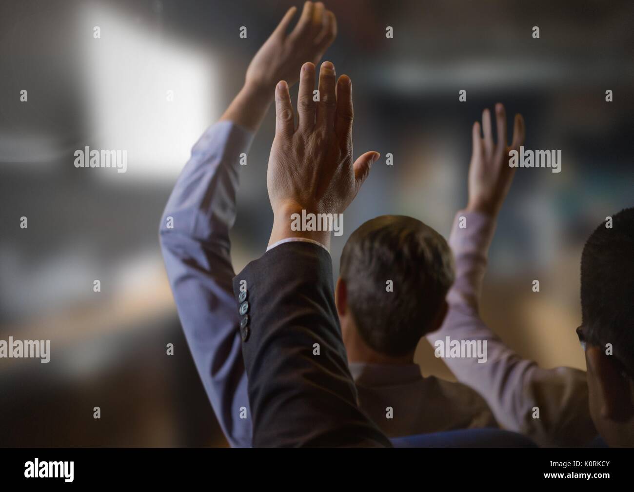 Digital composite of Business people with hands raised up at conference ...