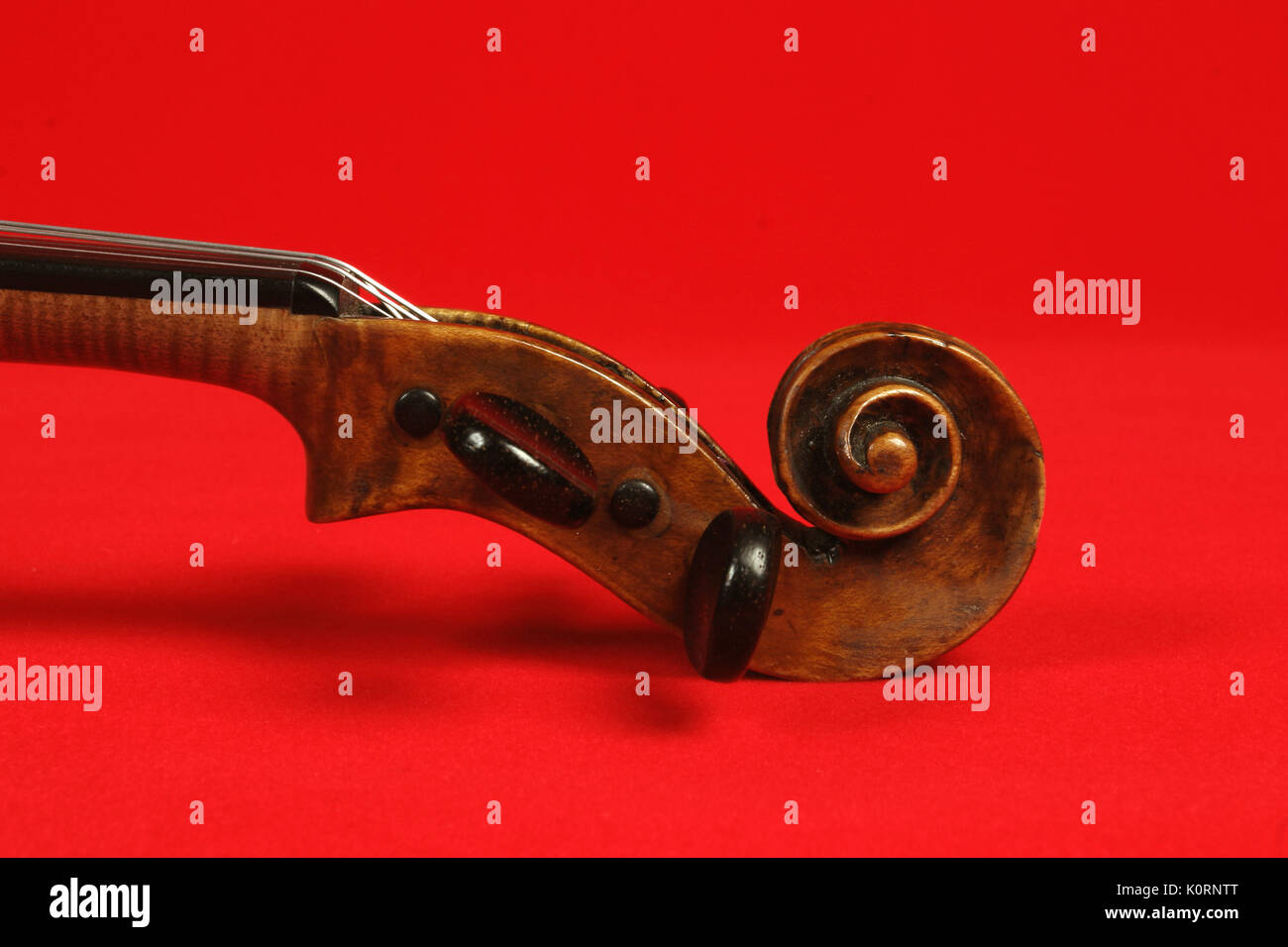 Violin scroll, 19th century English violin red background Stock Photo ...