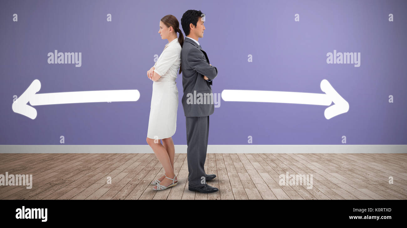 Portrait of serious business people standing back-to-back against room ...