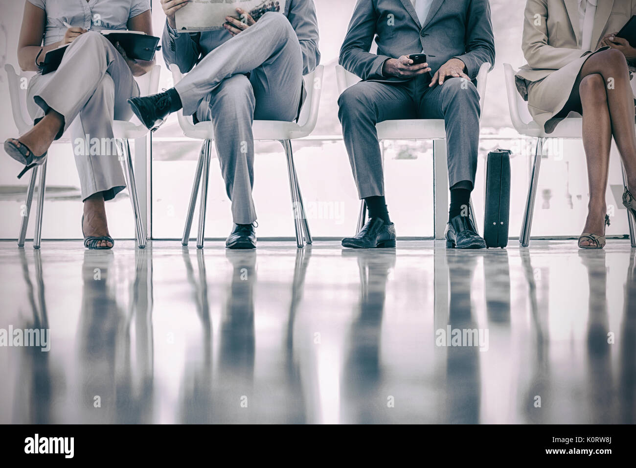 Low section of business people waiting in office Stock Photo - Alamy