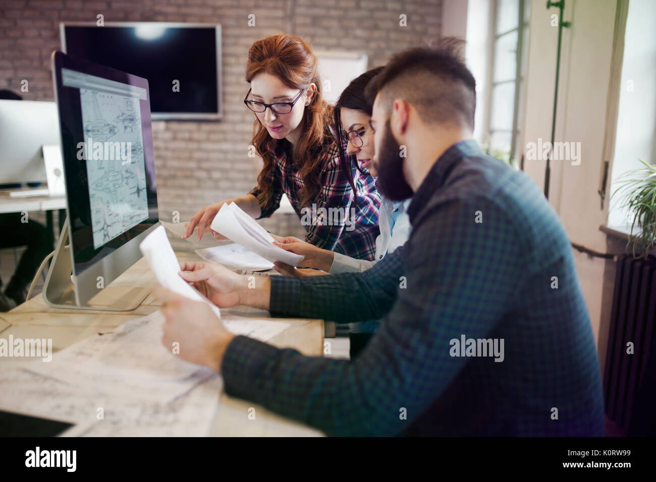 Group of young designers working as team Stock Photo - Alamy