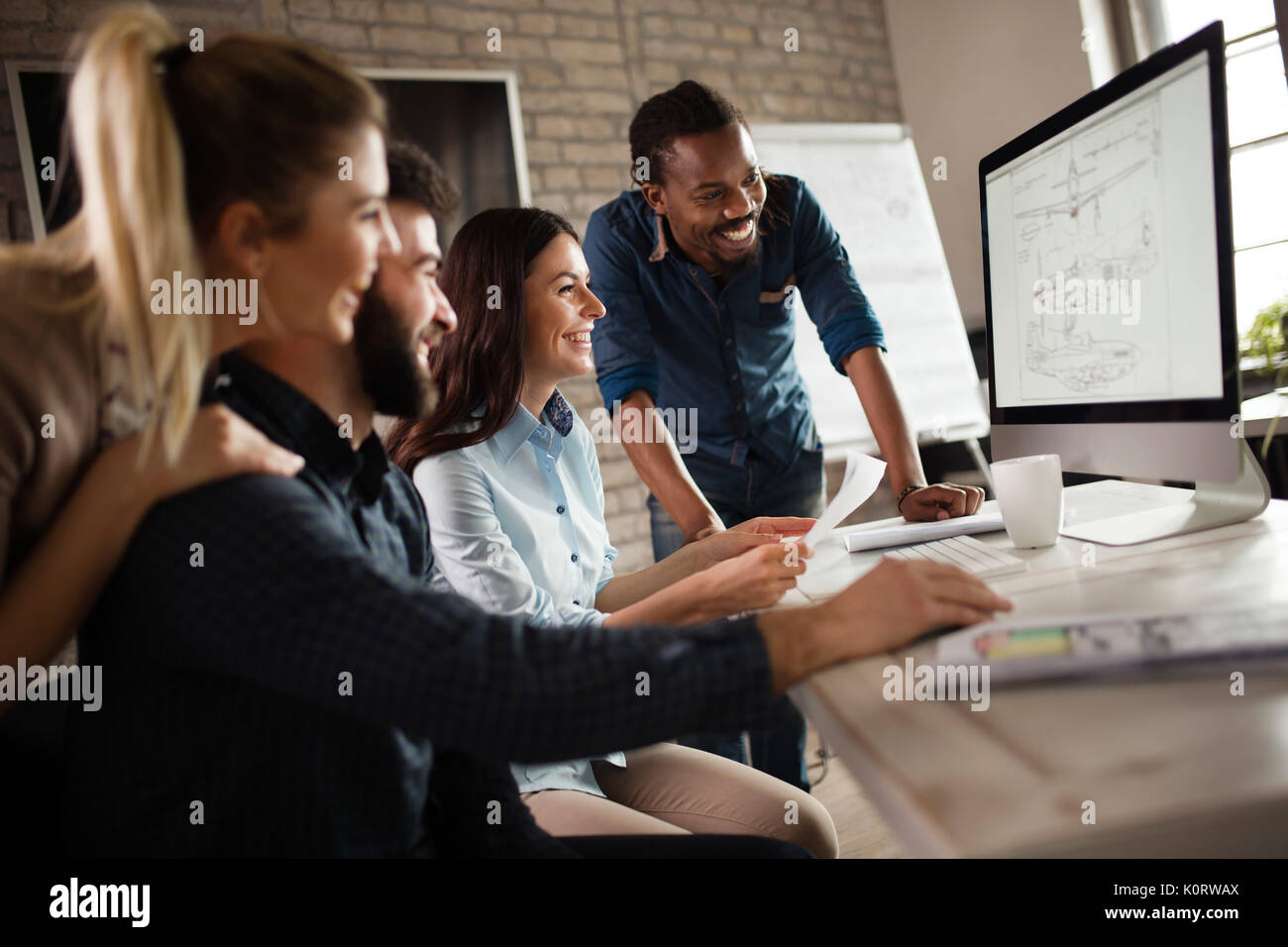 Group of young designers working as team Stock Photo - Alamy