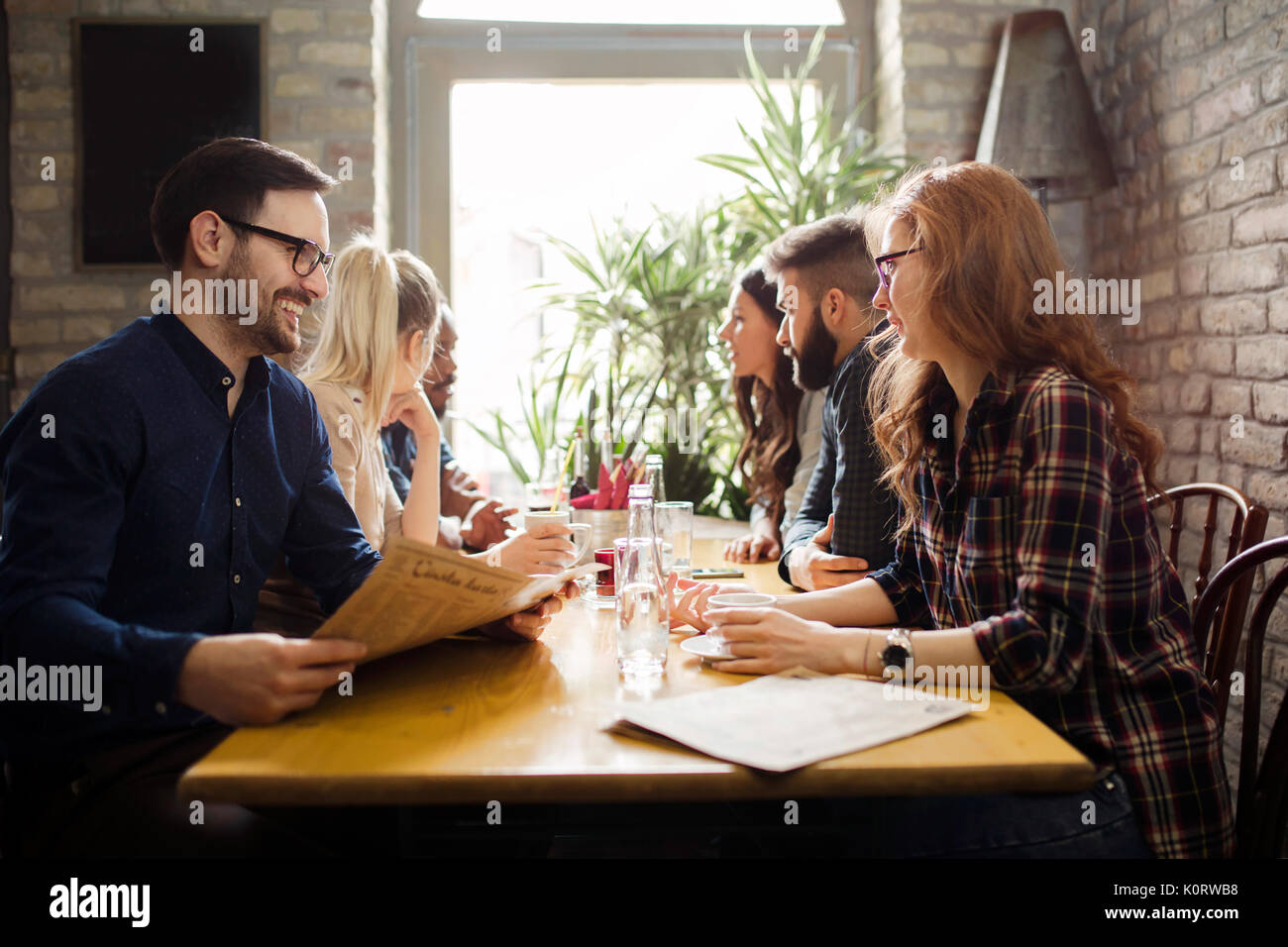 Happy colleagues from work socializing in restaurant Stock Photo - Alamy