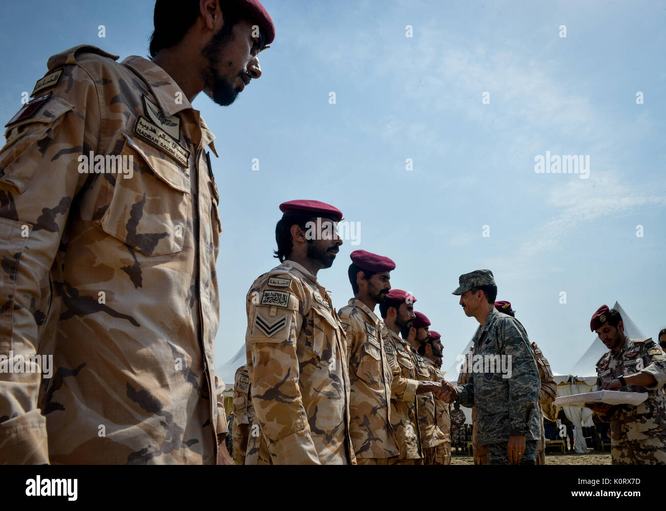 Col. David Keesey shakes the hand of a Qatari service member during a ...