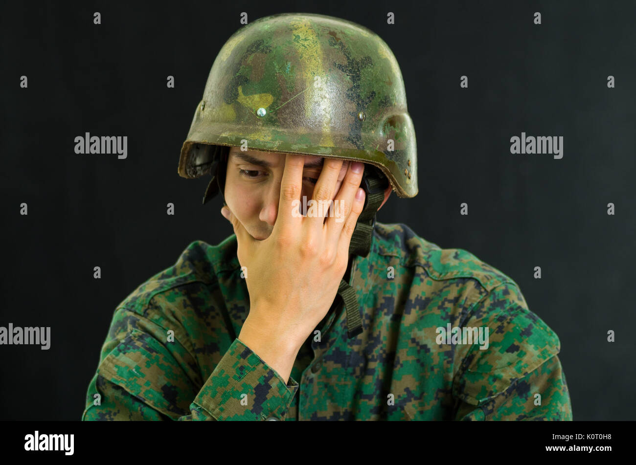 Handsome sad young soldier wearing uniform suffering from stress with ...