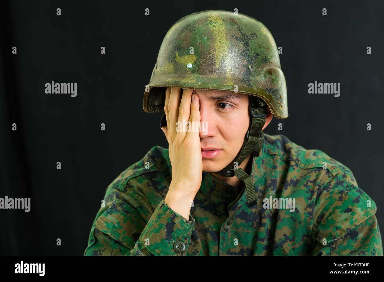 Handsome sad young soldier wearing uniform suffering from stress with ...