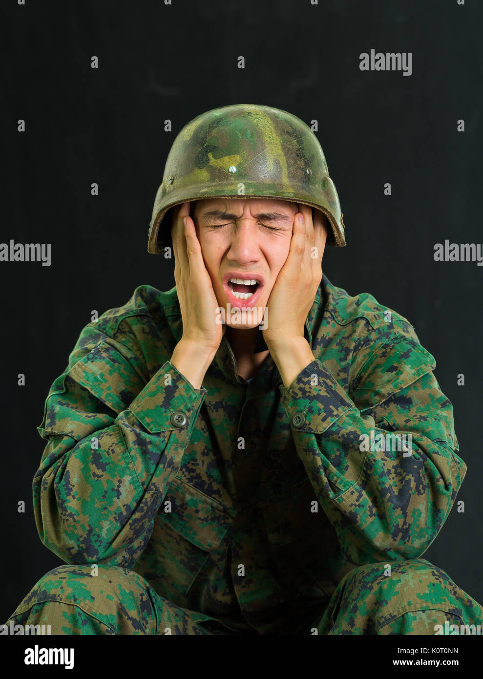 Handsome young soldier wearing uniform suffering from stress, screaming ...