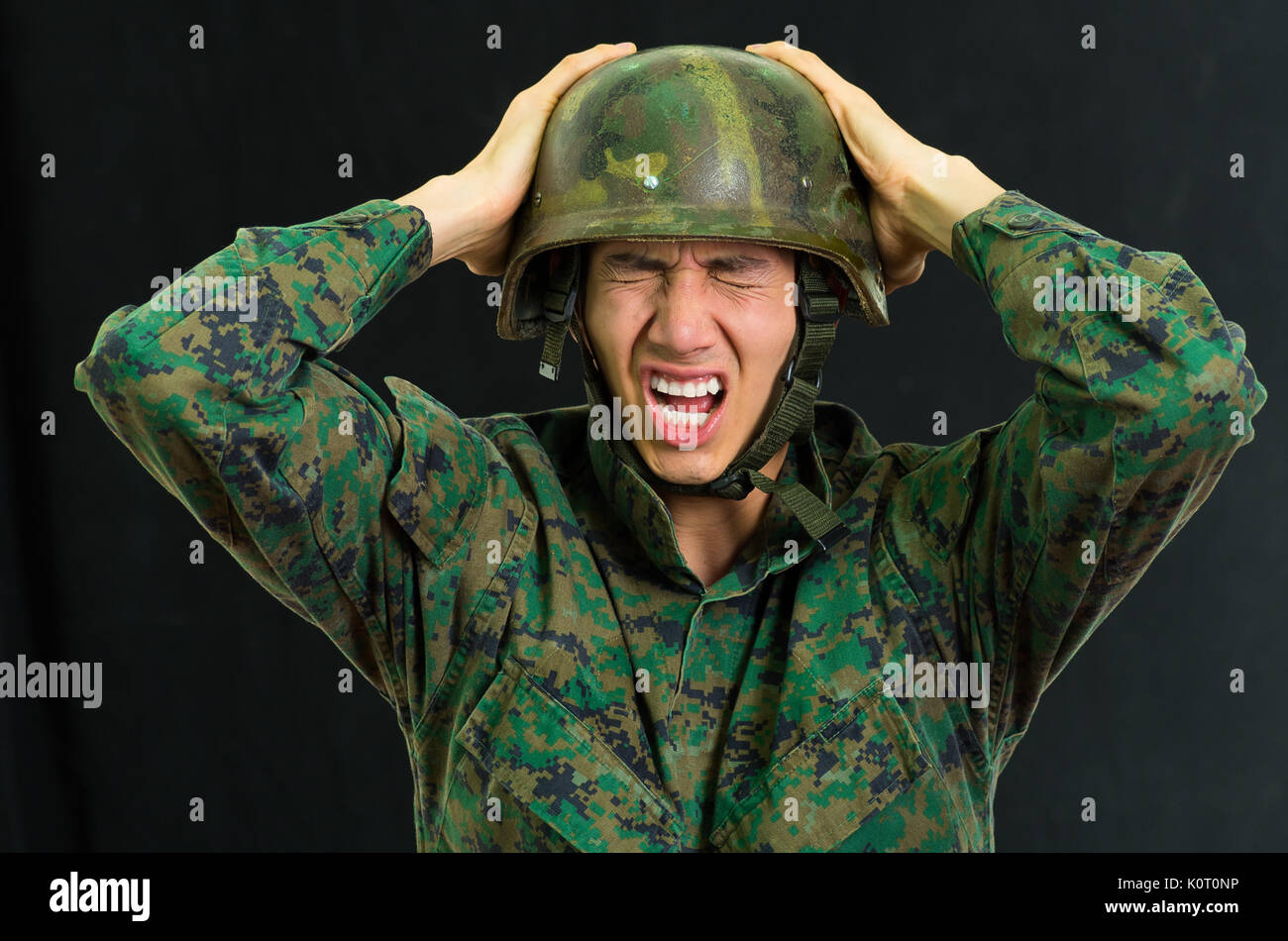 Handsome young soldier wearing uniform suffering from stress with his ...