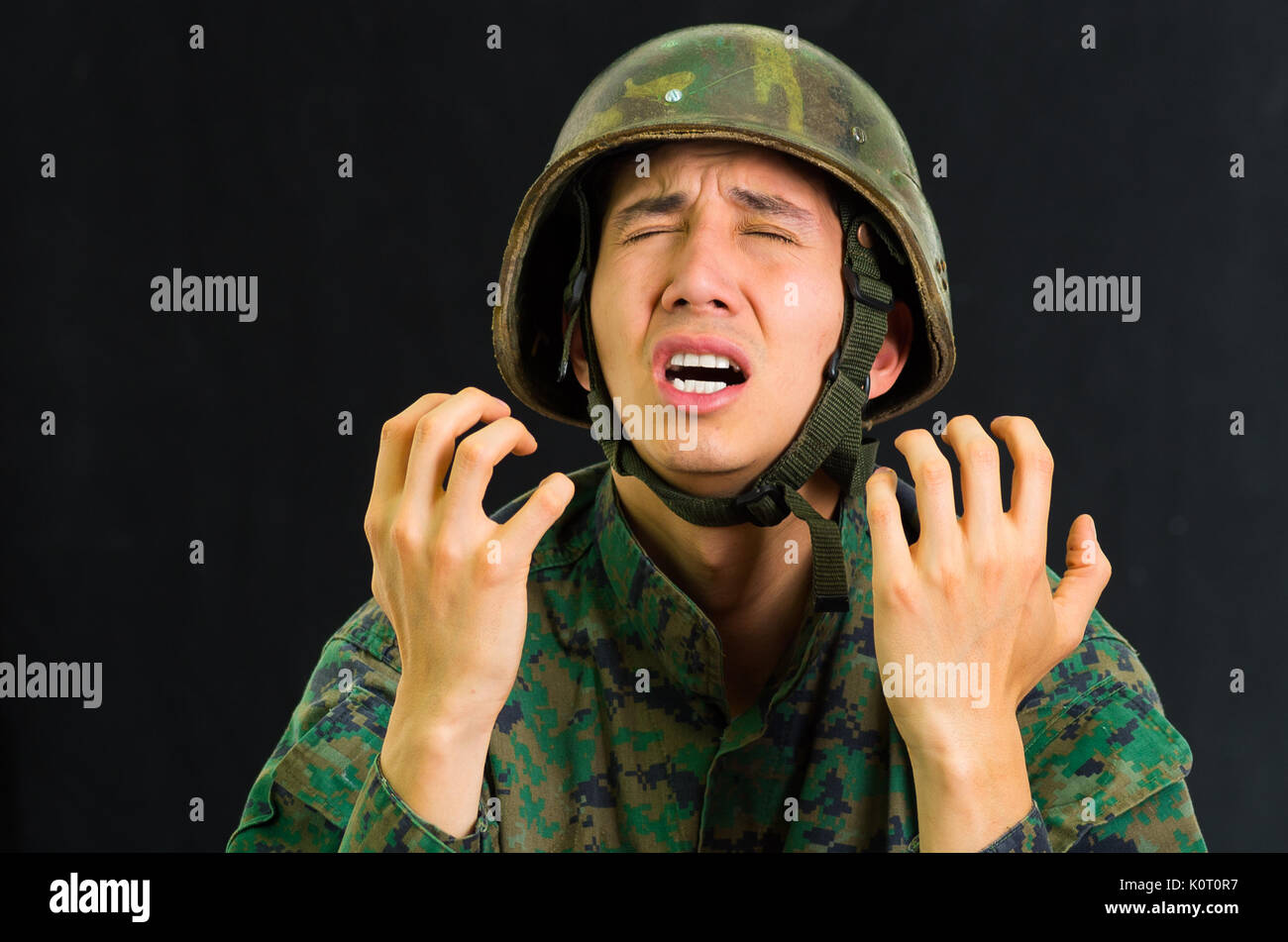 Handsome young soldier wearing uniform suffering from stress, screaming ...