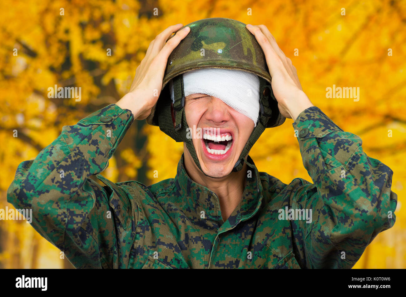 Handsome young soldier wearing uniform suffering from stress, with a ...