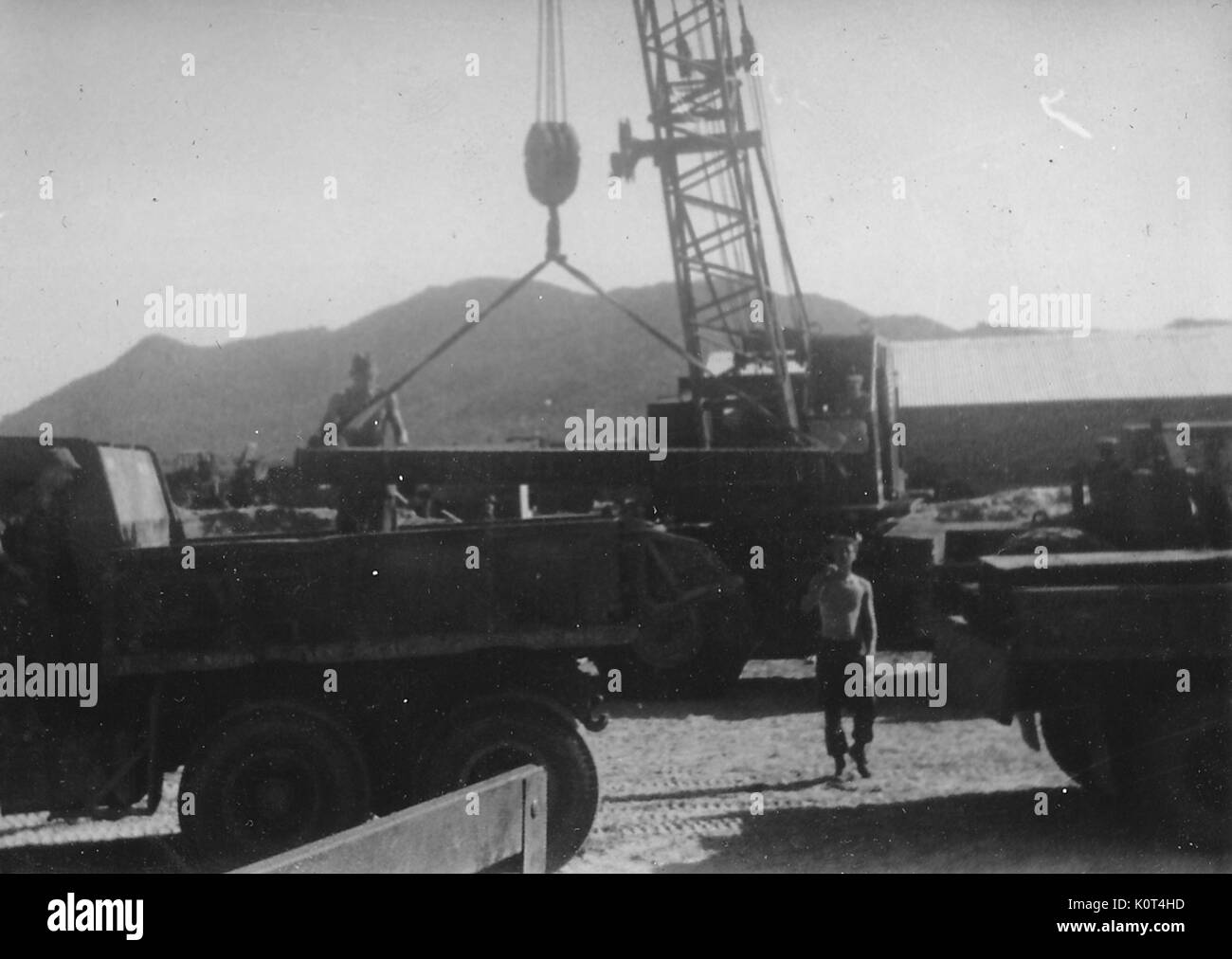 A photograph of United States Army servicemen unloading a steel i-beam ...