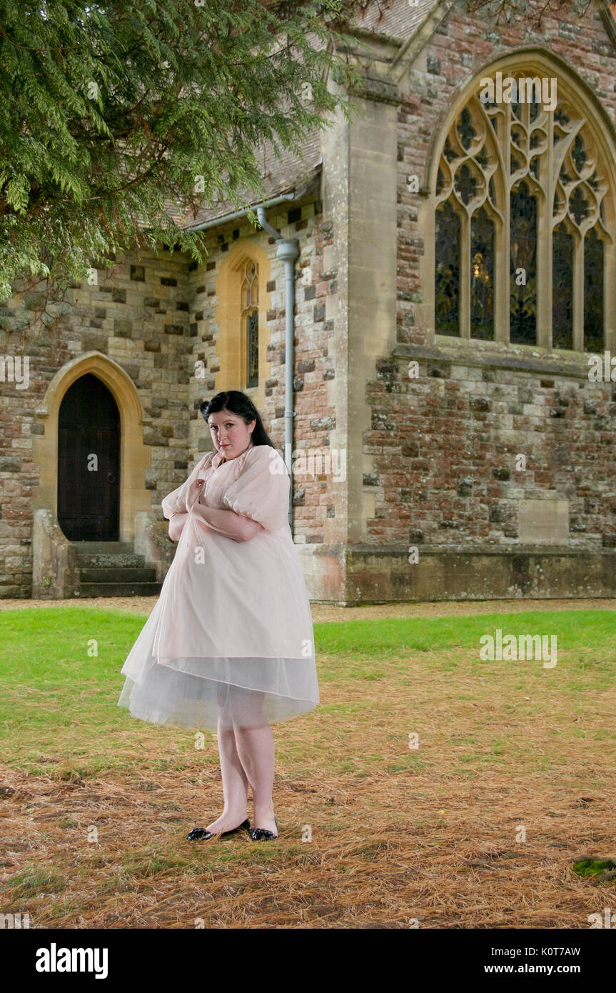Pretty girl outside a country church wearing a dress Stock Photo - Alamy