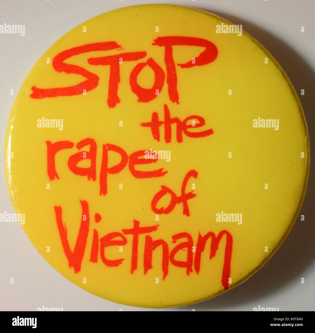 An anti-Vietnam War protest pin that consists of a yellow background ...